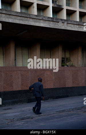 Mozambique, man walking in the street in traditional colored clothes ...