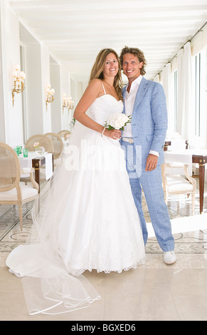Young bride and groom posing on shore promenade in front of sea ...