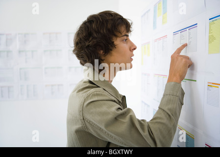 Male college student checking results posted on bulletin board Stock ...