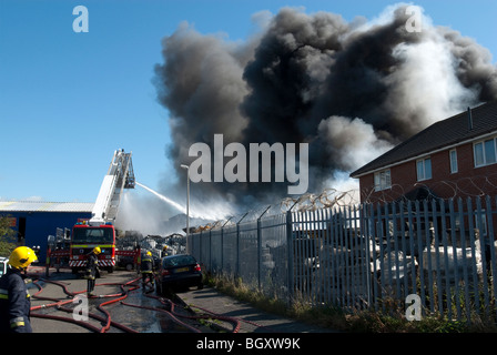 Huge industrial fire with large plumes of thick black smoke against ...
