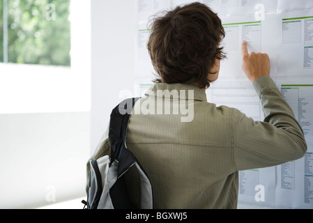 Male college student checking results posted on bulletin board Stock ...