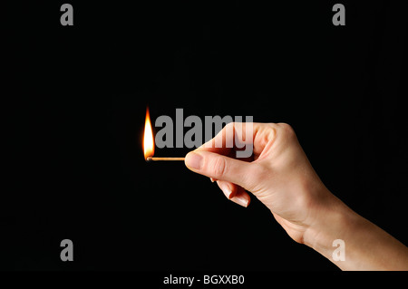 Hand holding lit match black background, studio photograph Stock Photo ...
