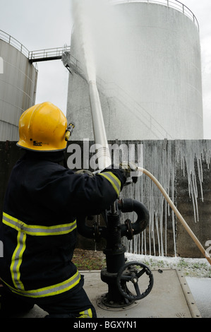 Fire Brigade spraying high expansion foam onto oil storage tank at ...