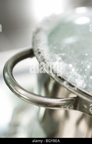 A pot of water boils over a one-burner propane-fuel camping stove Stock ...