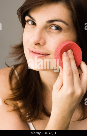 Beautiful woman with makeup sponge on white background Stock Photo - Alamy