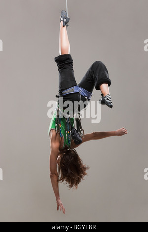 Female rock climber hanging upside-down on climbing wall Stock Photo ...