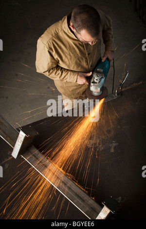 Worker cuts metal grinder. Sparks fly Stock Photo - Alamy