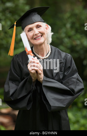Graduate students and an elderly woman holding certificates and smiling ...