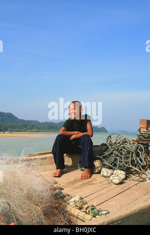 Child, boy, crouching on a boat, Chao Naam, Moken, Surin Islands Marine ...