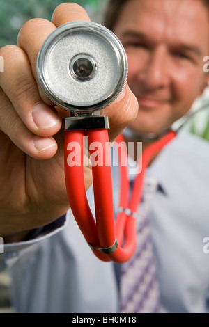 A white doctor with a red tube stethoscope prepares to check a patient ...