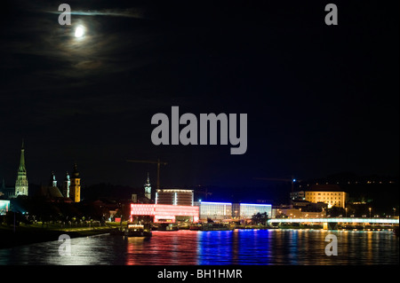 The full moon shining above the city in the pink sunset sky for ...