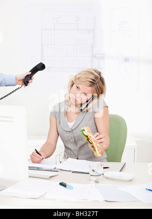 Young woman eating sandwich when listening to boyfriend explaining ...