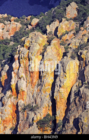 Steep cliffs covered in lichen with waterfall and blue water Stock ...