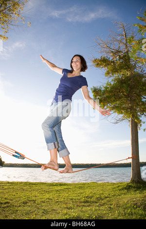 Young woman on a slackline Stock Photo - Alamy