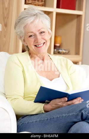 Senior caucasian woman reading a book over isolated background very ...