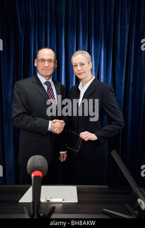 Man and woman shaking hands at podium Stock Photo - Alamy