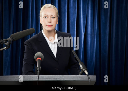 A woman in a suit at a lectern Stock Photo - Alamy