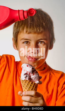 Smiling boy pours syrup onto pancake from spoon Stock Photo - Alamy