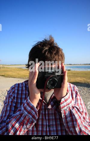 Man holding a camera infront of his face Stock Photo - Alamy