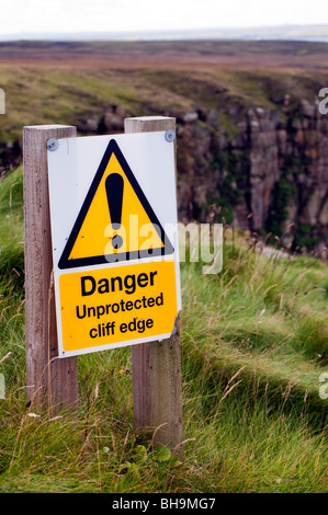 Danger, unprotected cliff edge warning sign with sea background Stock ...