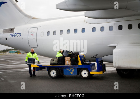Airport workers are loading and unloading plane and using their small ...