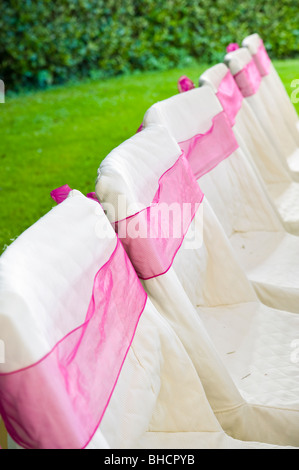Row of White Chairs with Pink Ribbons Stock Photo - Alamy