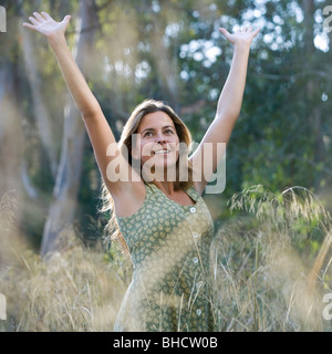 Smiling woman raising her arms above her head Stock Photo - Alamy