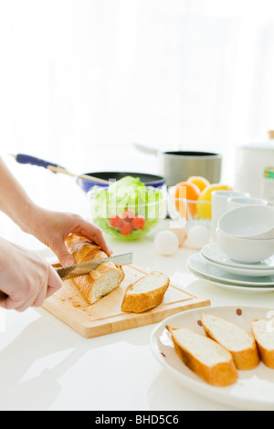Man cutting baguette Stock Photo - Alamy
