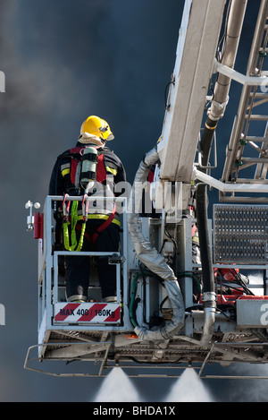 Firemen in cage of Hydraulic Platform with smoke behind Stock Photo - Alamy