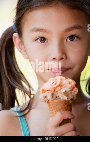 Girl with ice cream cone in front of hedge Stock Photo - Alamy