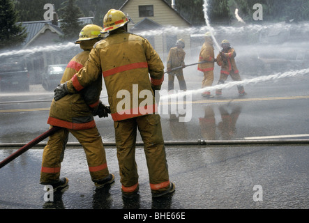 Firemen spray each other in a competition at the end of a Fourth of ...