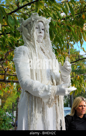 A female 'living statue', dressed extravagantly in white with lacy ...