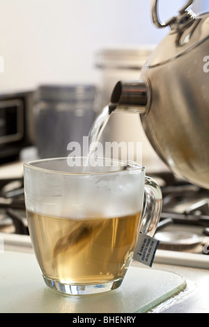 Teabag steeping in boiling water in a teacup during the brewing of a ...