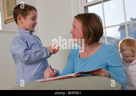 Boy signing the word 'Write' in American Sign Language sitting with his ...