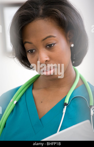 African American woman nurse wearing headphones working at office desk ...