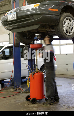 Auto mechanic performing the motor oil change Stock Photo - Alamy