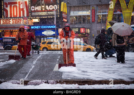 Workers shovel snow in Times Square during a storm that is covering the ...
