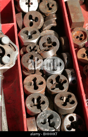 Steel metalworking die at cutting screw thread on a brass rod. Sharp ...