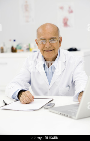 Doctor completing paperwork, portrait Stock Photo - Alamy