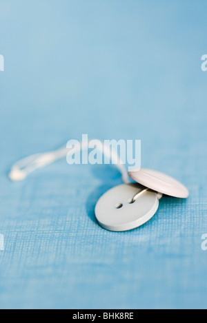 Buttons threaded together Stock Photo - Alamy