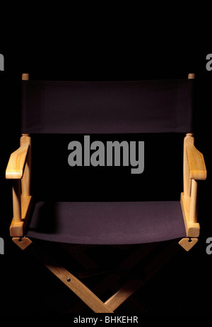 Directors chair lit with spotlight. Isolated. Black background Stock ...