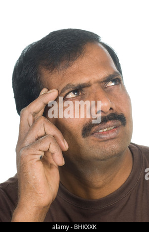 Indian man trying to remember something with hand on head against a ...