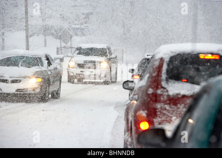 Winter traffic jam during snowstorm with poor visibility. Snow sign and ...