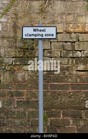 Sign or warning notice of a wheel clamping zone Stock Photo - Alamy