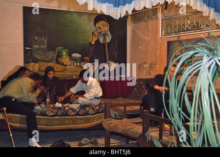 Iranian people dining and smoking traditional water pipe at a ...