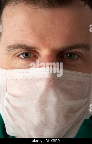 A man wearing a face mask to protect against coronavirus waits at a bus ...