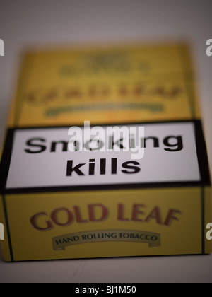 A packet of rolling tobacco with a health warning sign on it. England ...