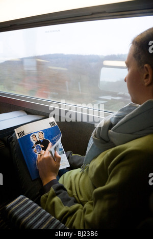 French woman passenger reading the TGV magazine inside a Train Grande ...