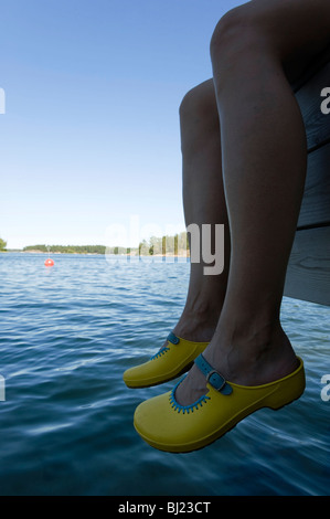 People legs hanging dangling on touristic charter boat Stock Photo - Alamy