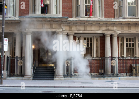 Smoking coming out from the ground in front of victorian style houses ...